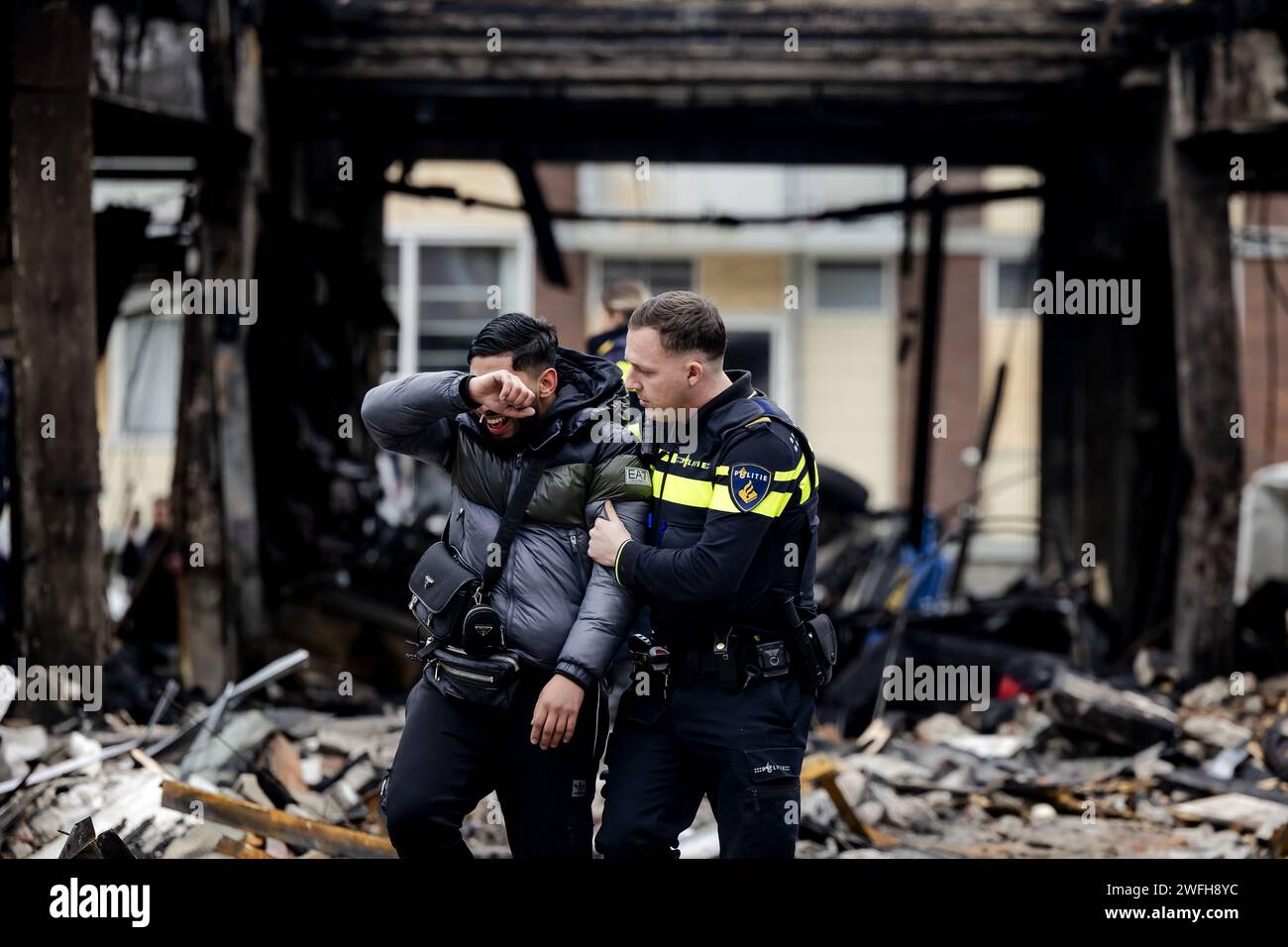 ROTTERDAM - A family member is escorted from the site where an ...