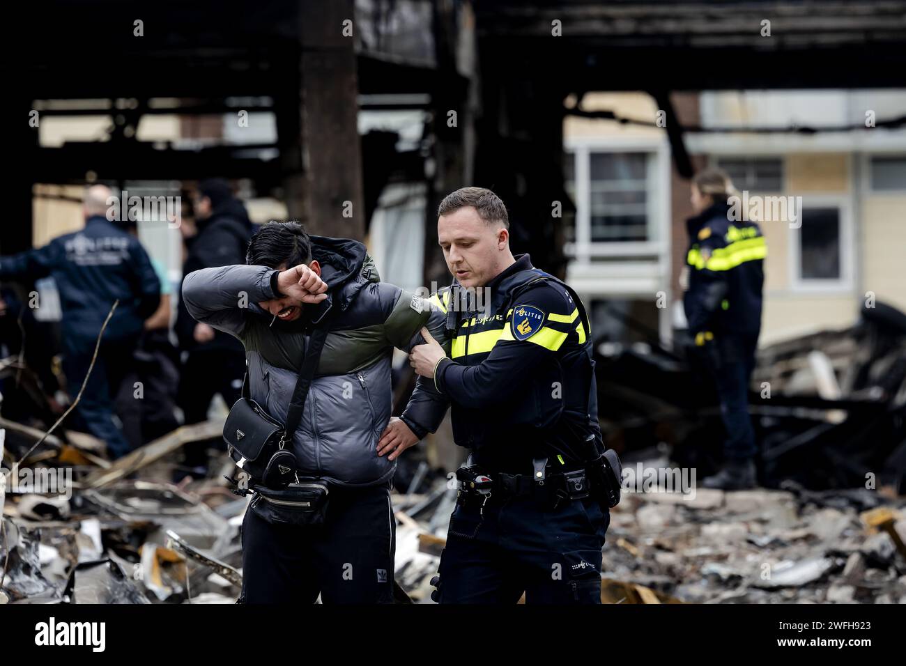 ROTTERDAM - A family member is escorted from the site where an ...