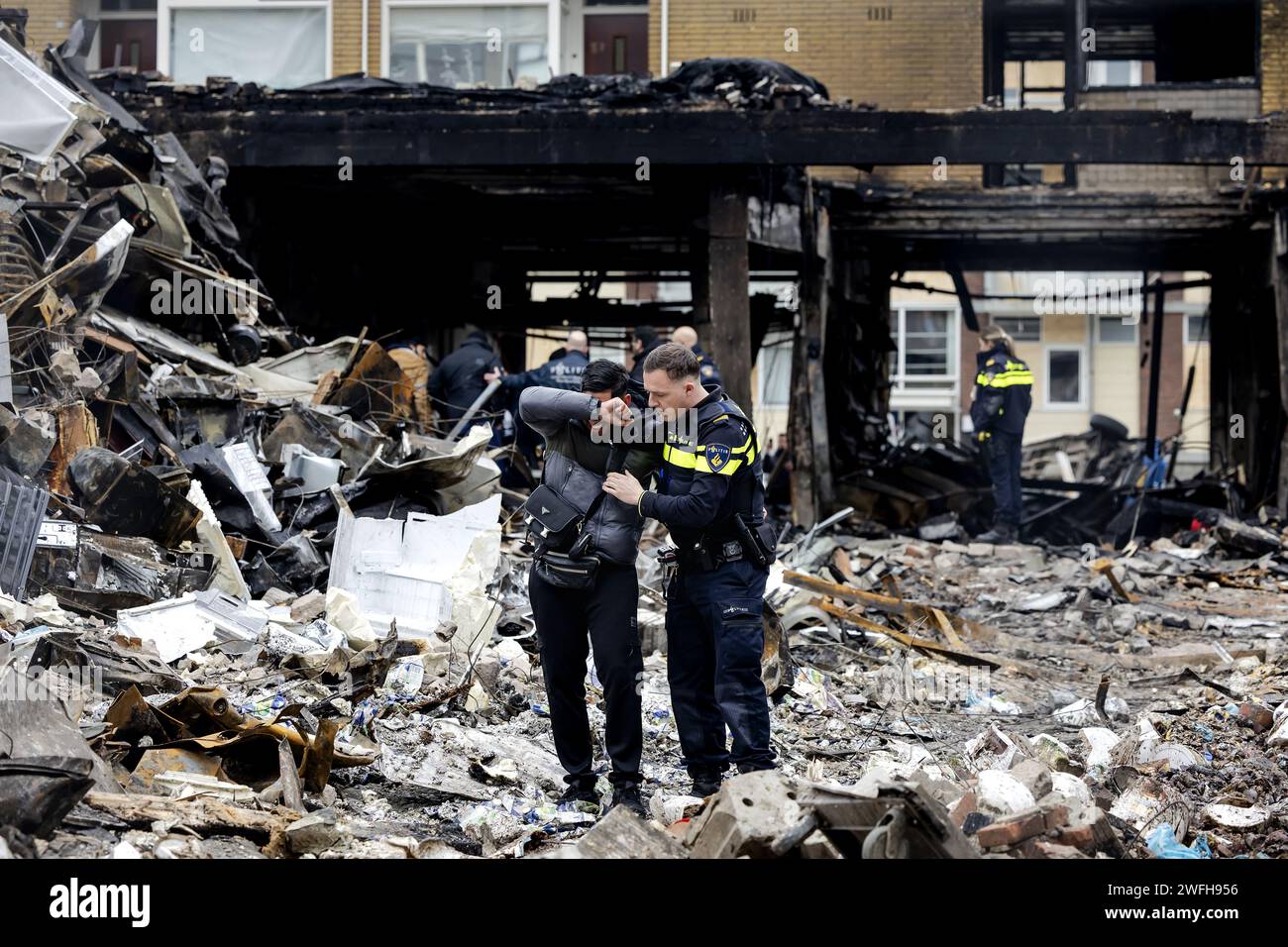 A family member is escorted from the site where an explosion took place ...