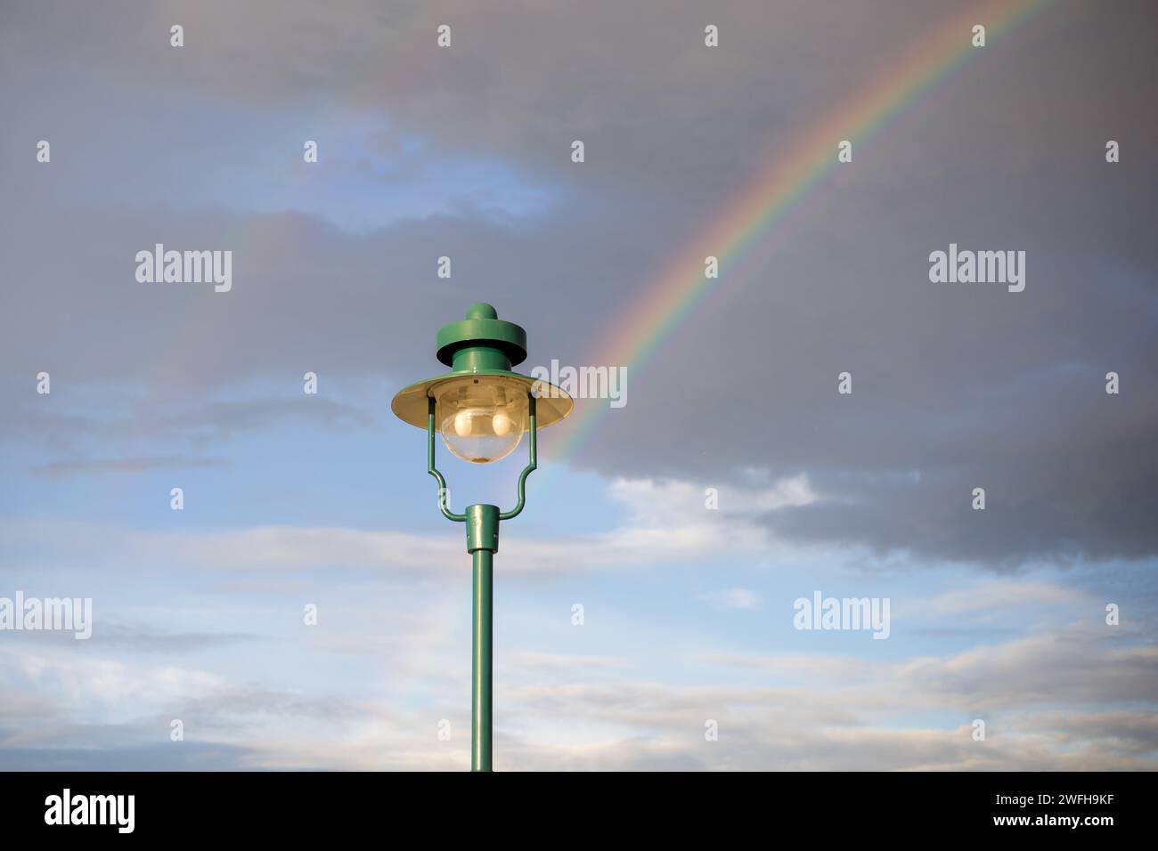 rainbow behind a street pole lamp Stock Photo - Alamy