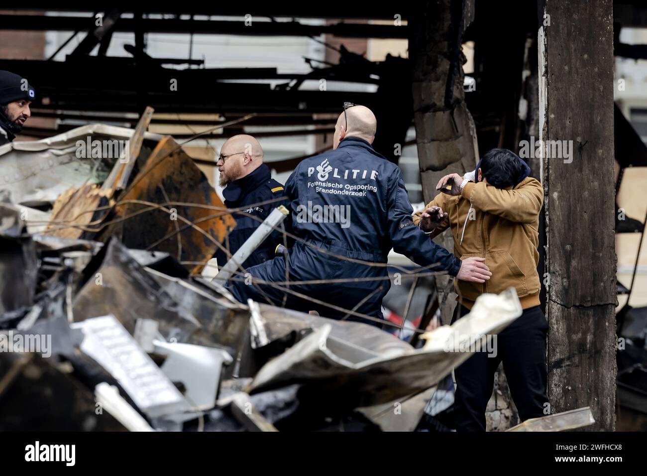 ROTTERDAM - A family member is escorted from the site where an ...