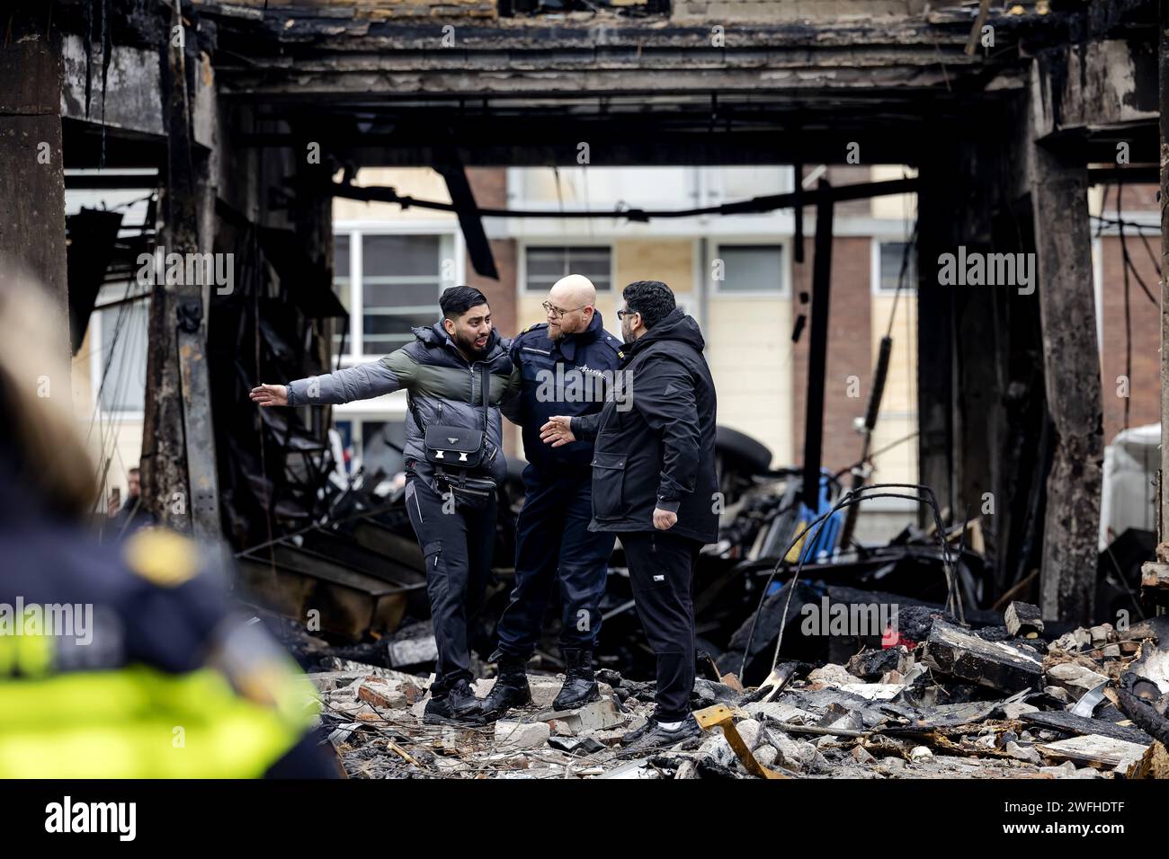 ROTTERDAM - A family member is escorted from the site where an ...