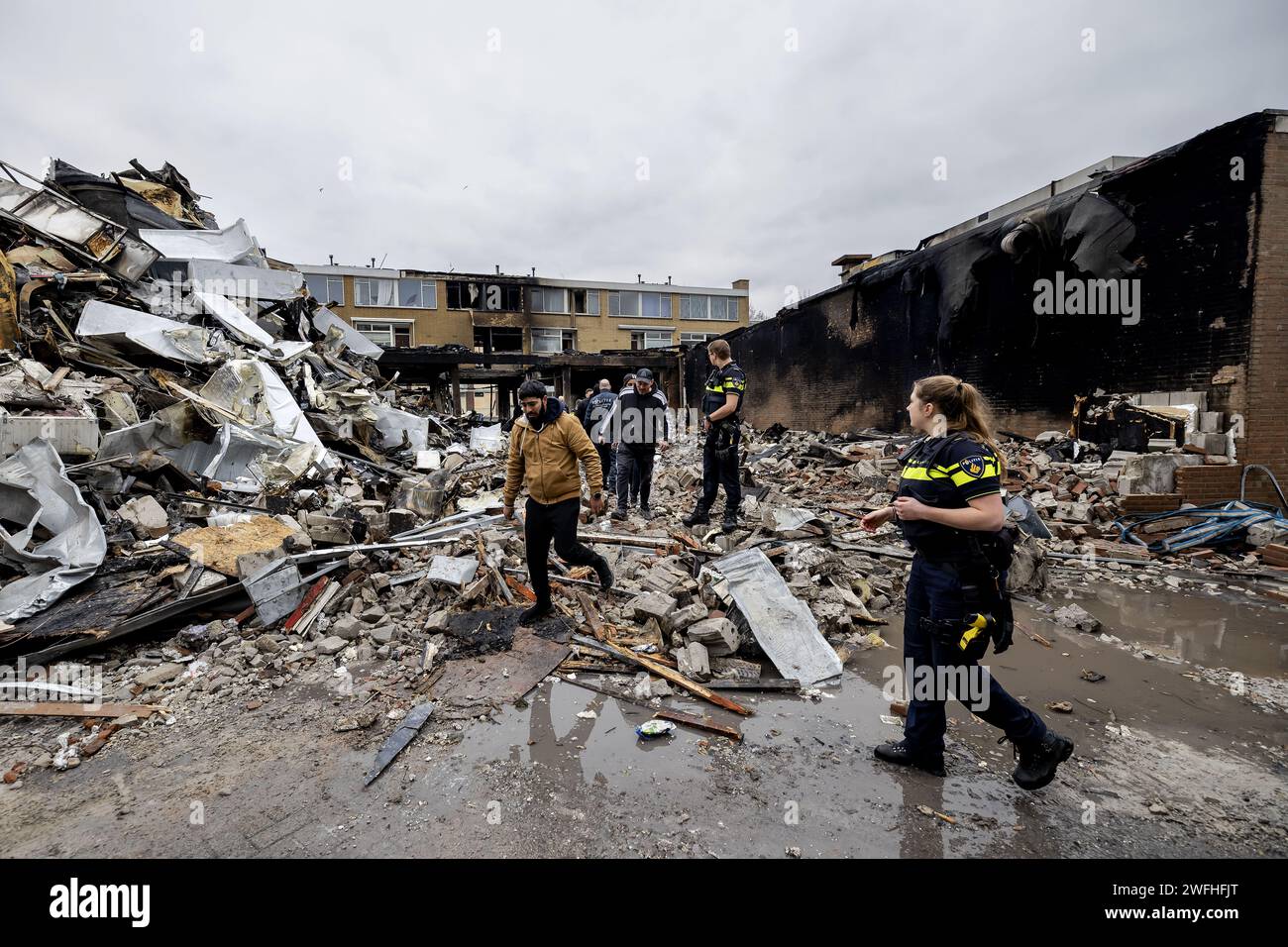 ROTTERDAM - A family member is escorted from the site where an ...