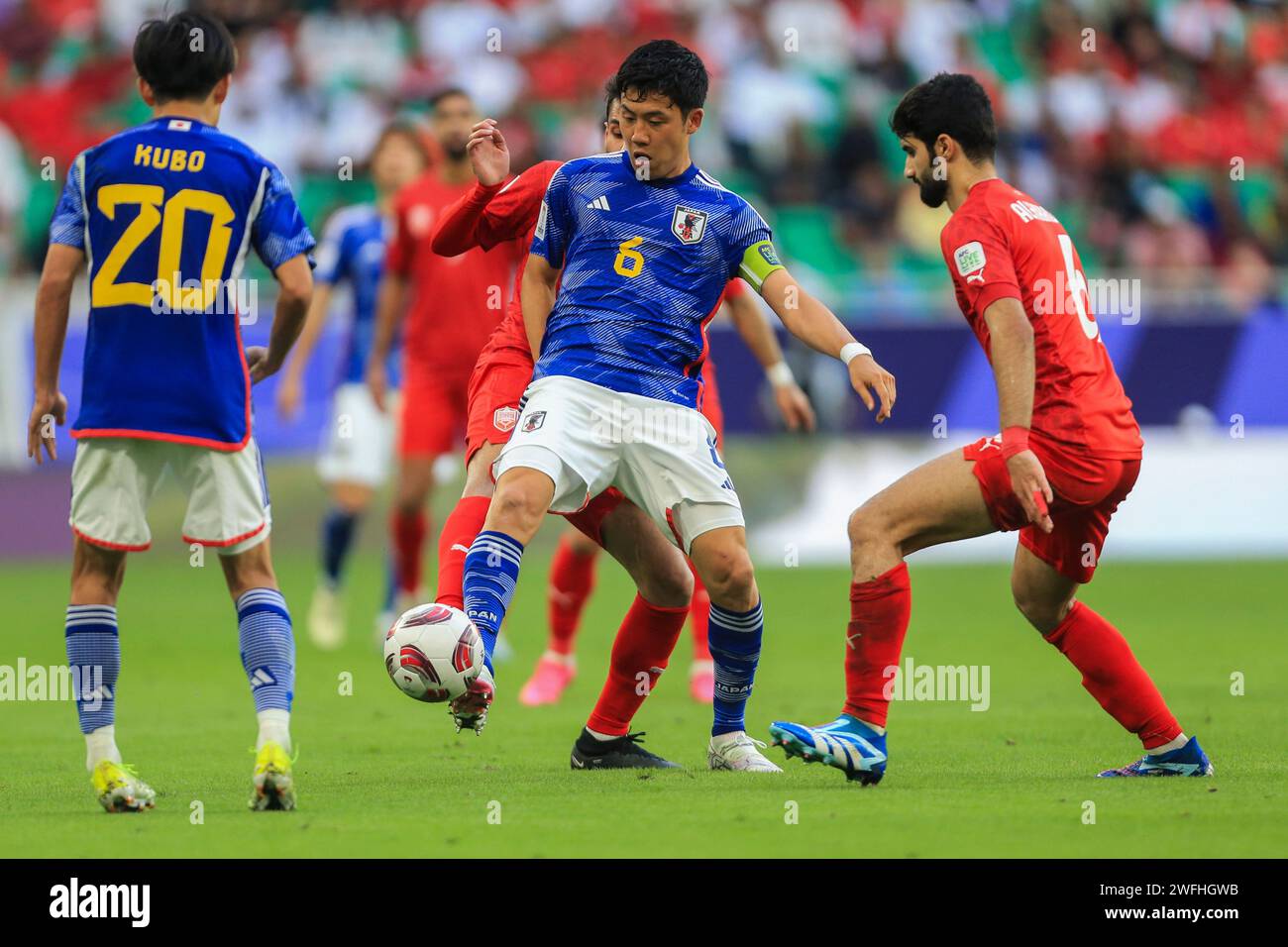 Japan's Wataru Endo controls the ball next to Bahrain's Mohamed ...