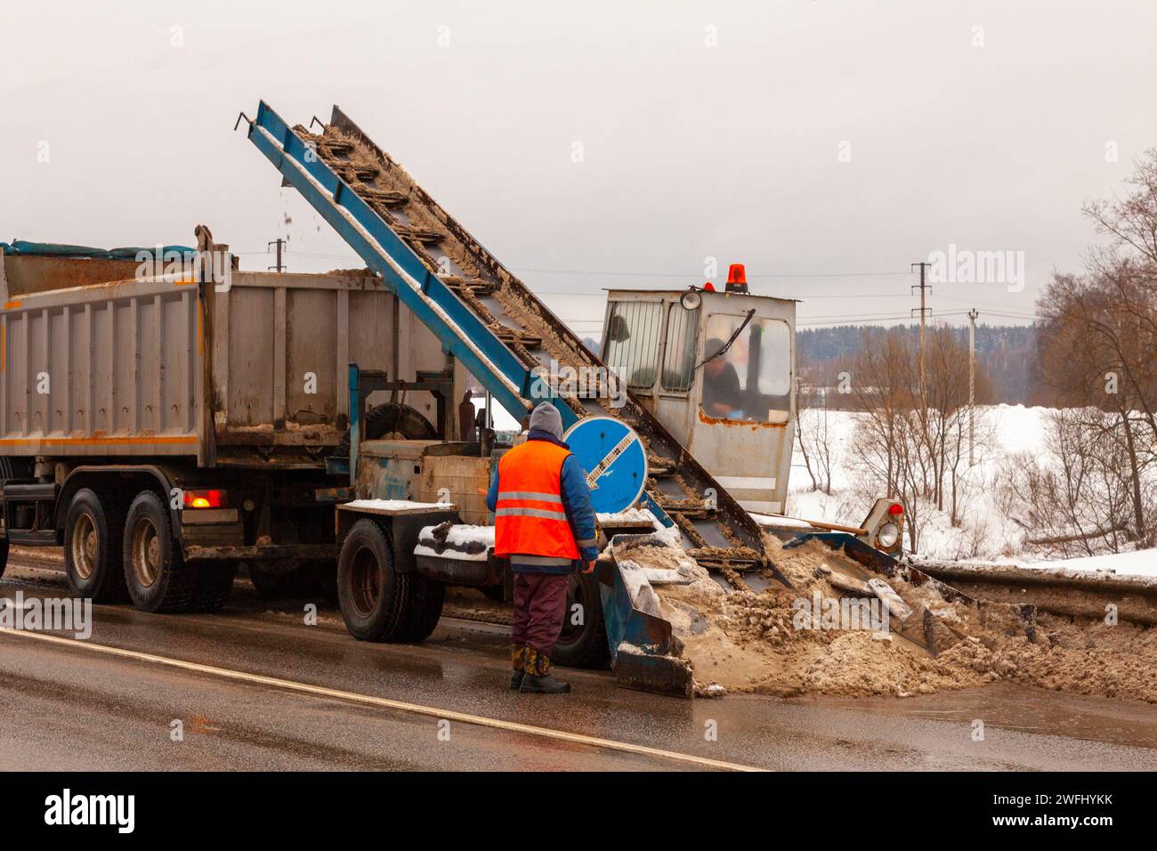 Utility workers clear the road from fallen snow Stock Photo - Alamy