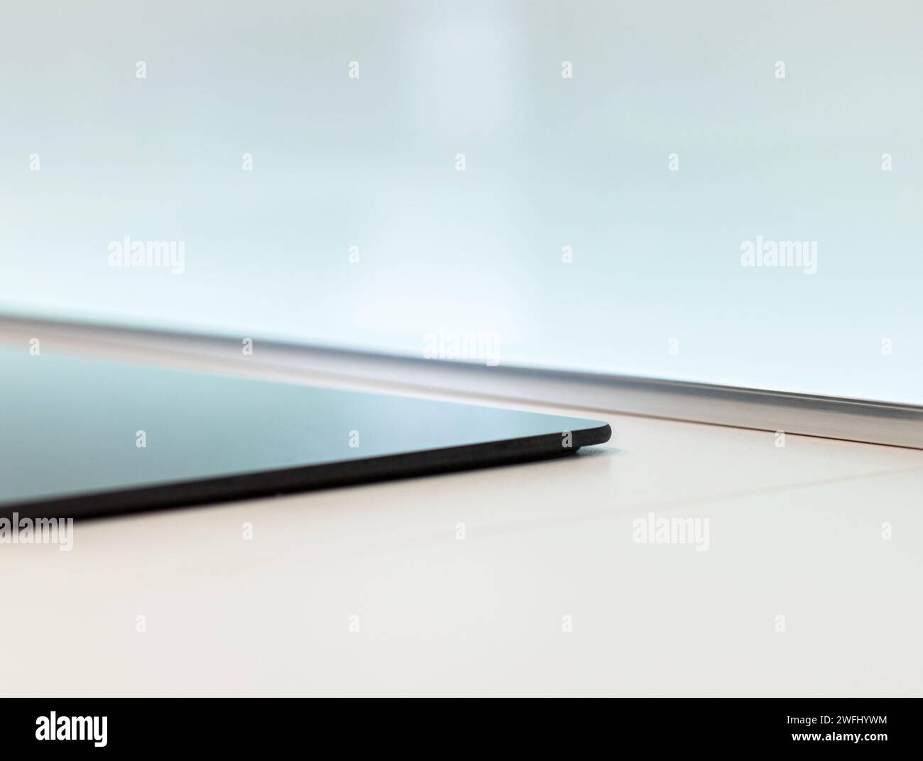 Detail of the corner of an induction hob. The glass is black and ...