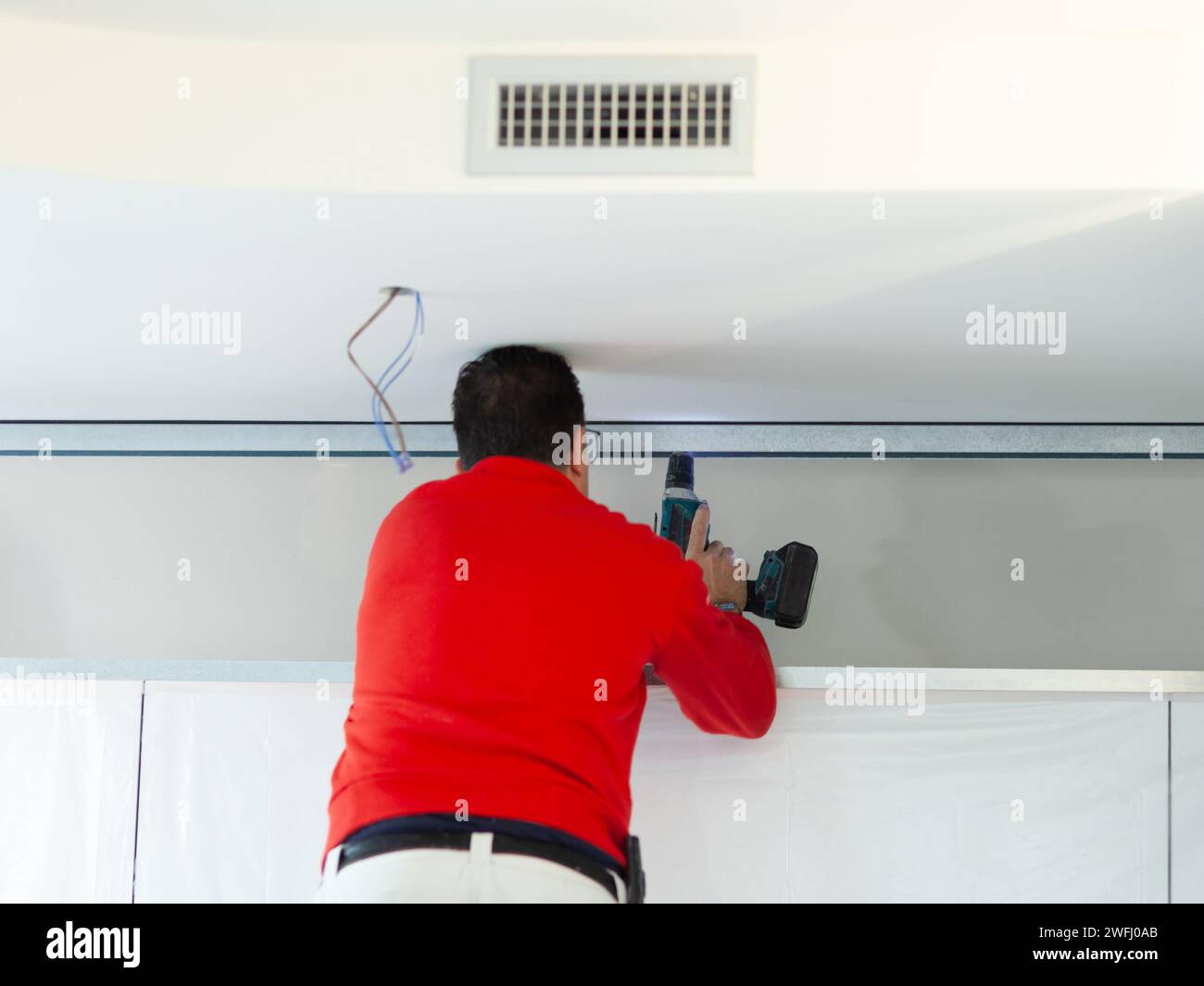 Plasterboard worker installs a plasterboard wall on the kitchen ...
