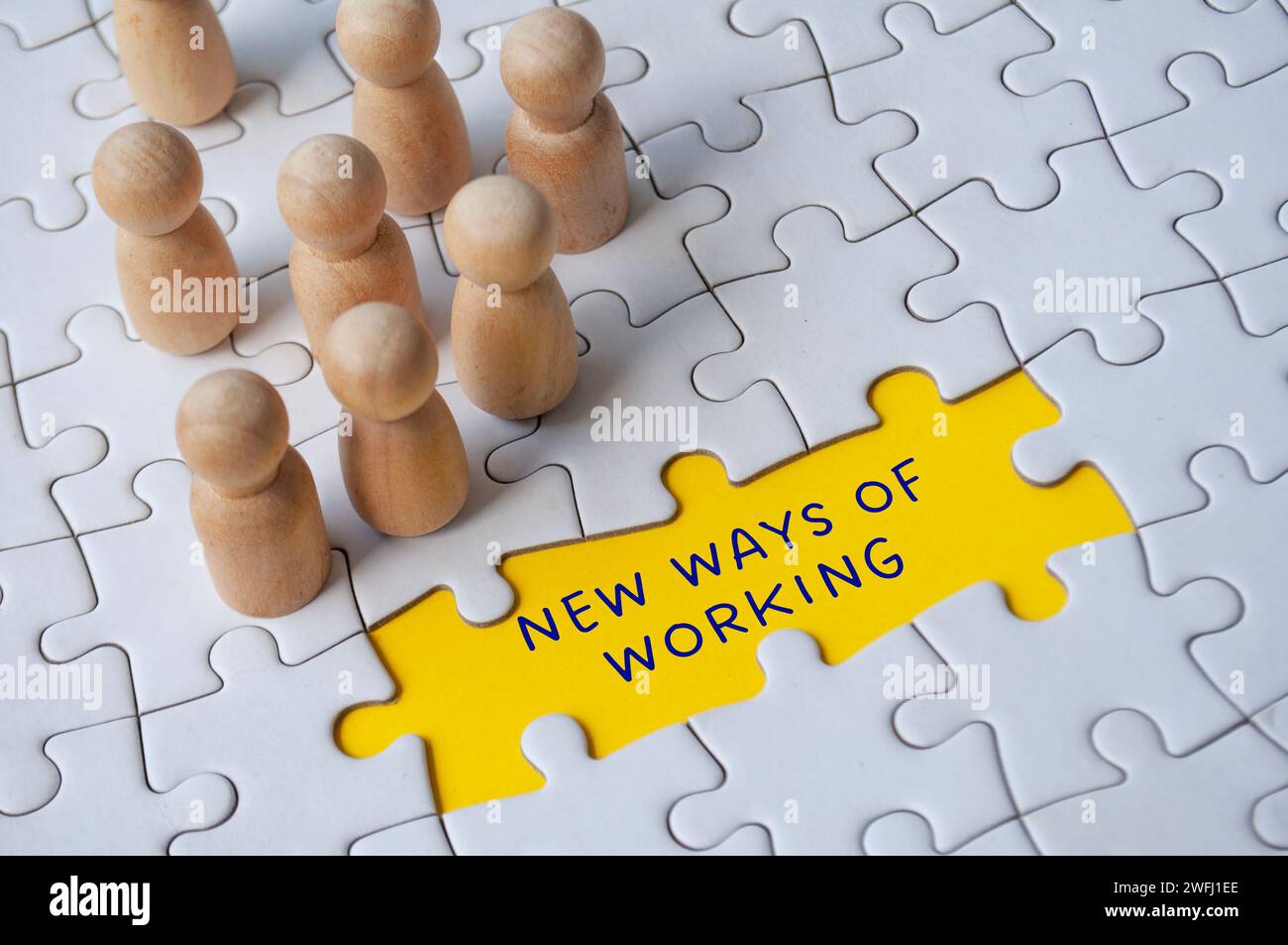 Empty jigsaw puzzle with text - new ways of working surrounded by ...