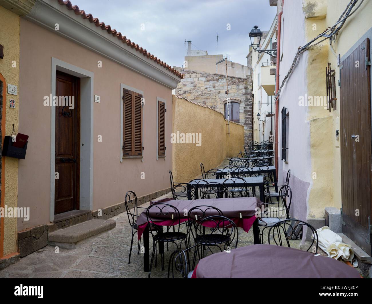 Tables and chairs set up outside on a lane in Castelsardo, Santa Teresa ...