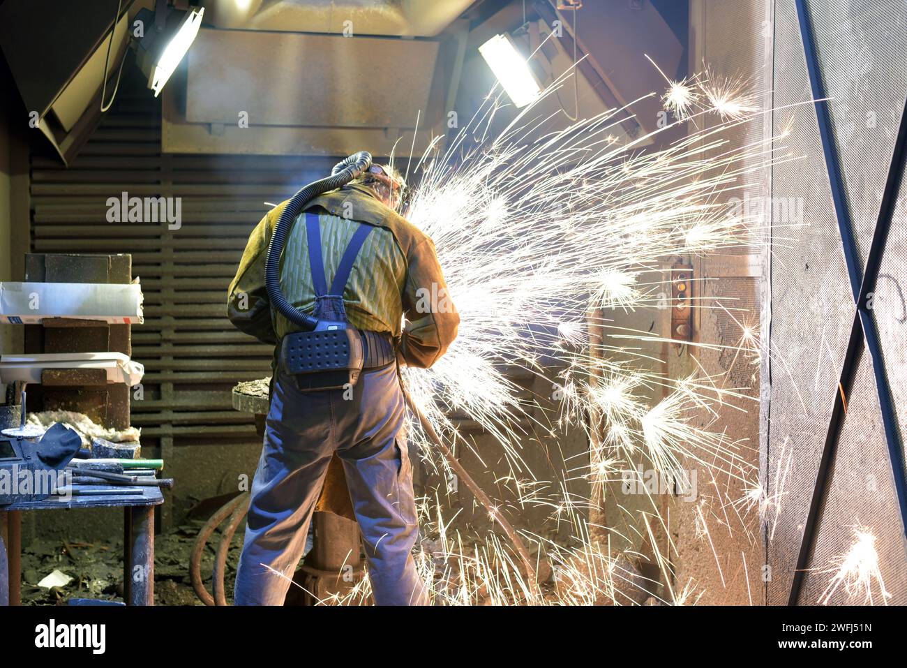 Welder in protective clothing at the workplace in an industrial company ...