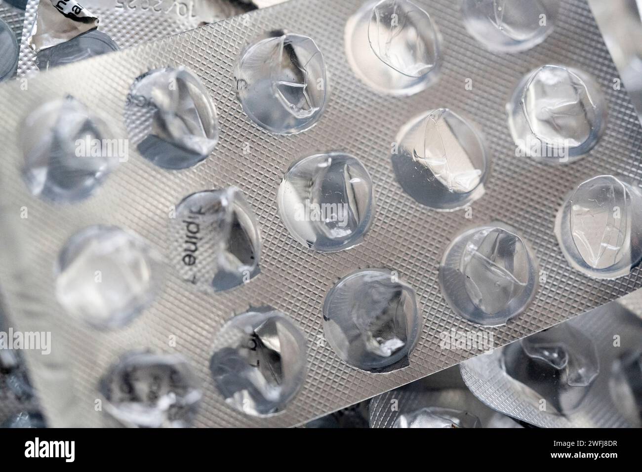 A detail of generic silver medication foils that once contained tablets ...