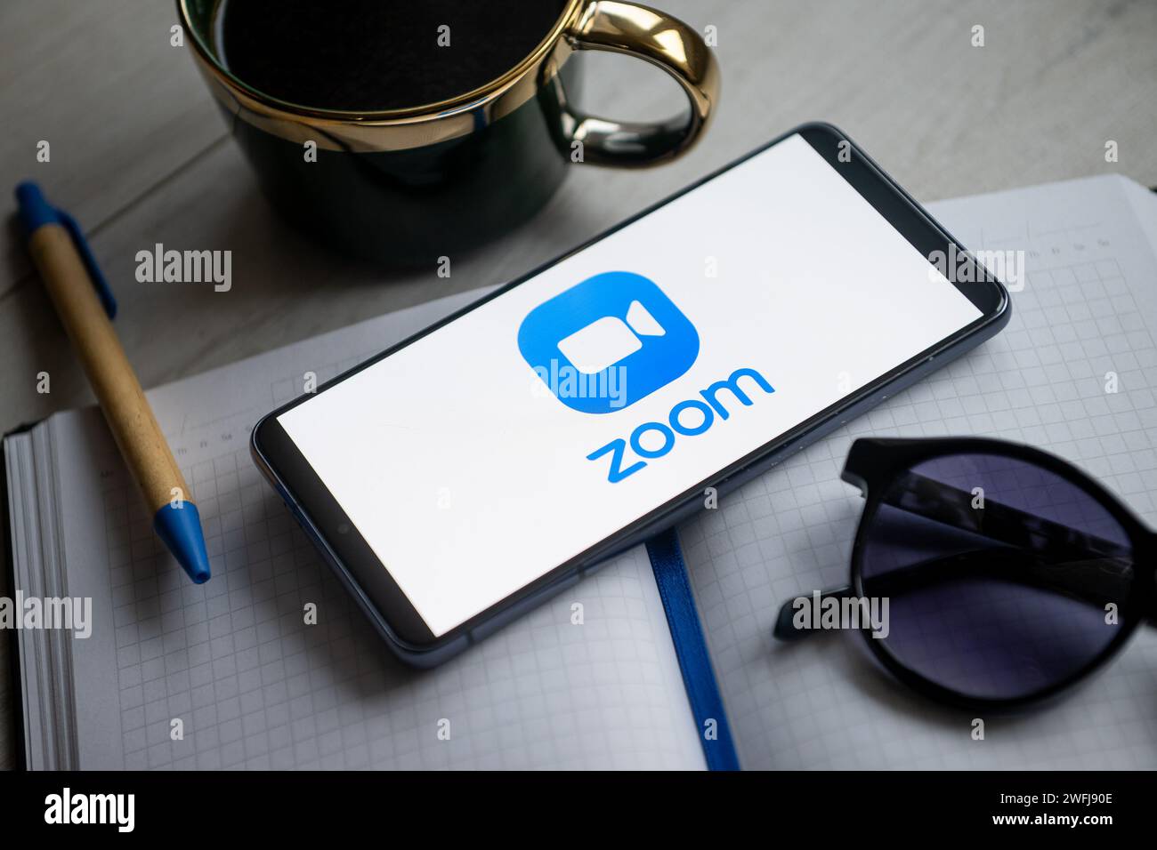 In this photo illustration a Zoom logo seen displayed on a smartphone ...