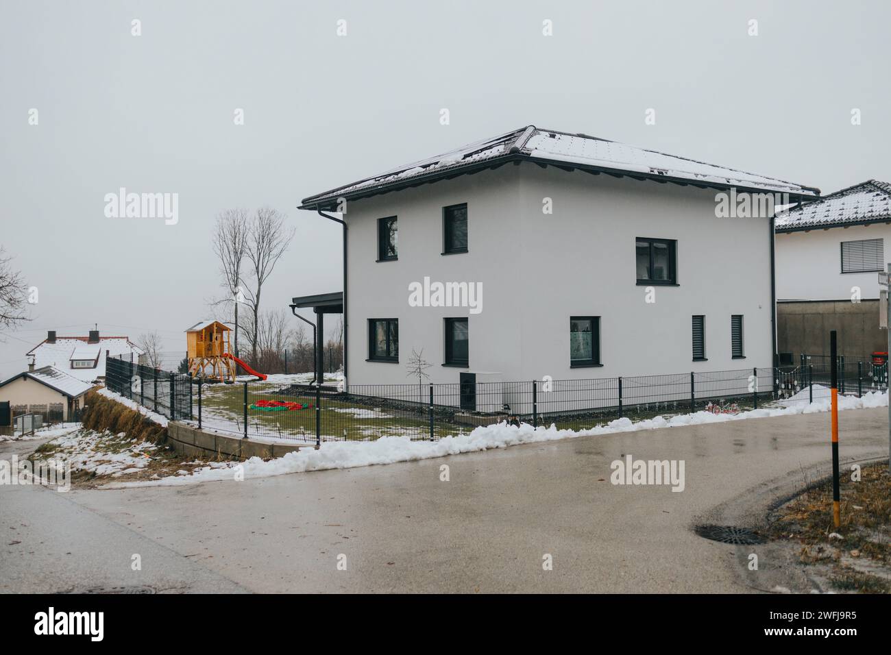 A snowy landscape surrounds a pristine two-story white house Stock ...