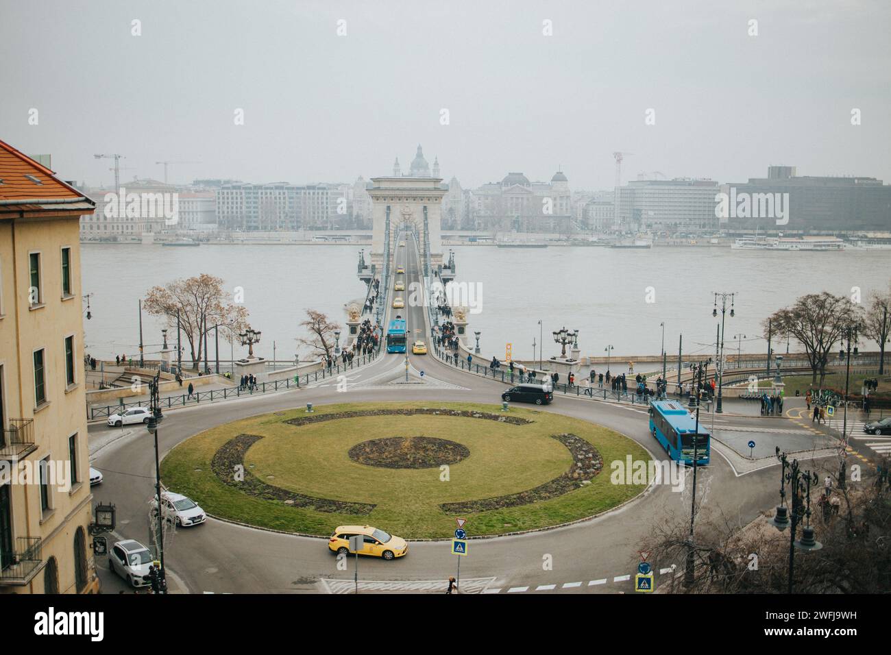 Traffic flowing around a city roundabout with a distant bridge Stock ...