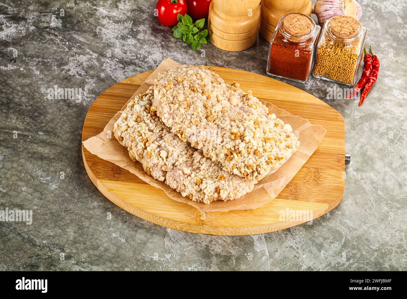 Breaded raw breaded meat schnitzel for roast Stock Photo - Alamy