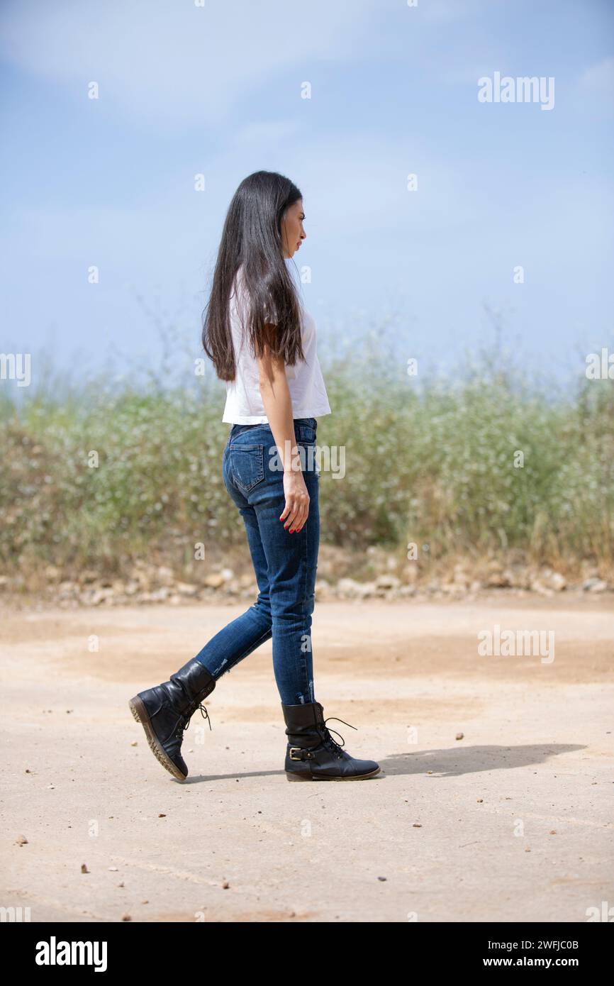 Side view of young woman walking Stock Photo - Alamy