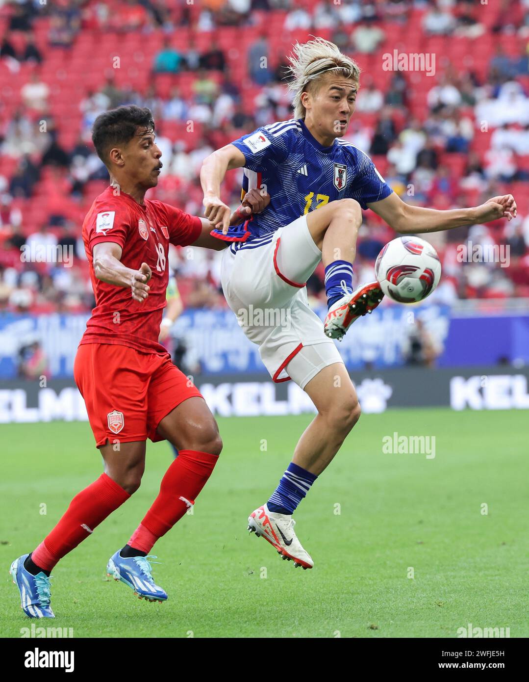 Doha, Qatar. 31st Jan, 2024. Japan's Nakamura Keito (R) vies with Bahrain's Mohamed Adel during ...