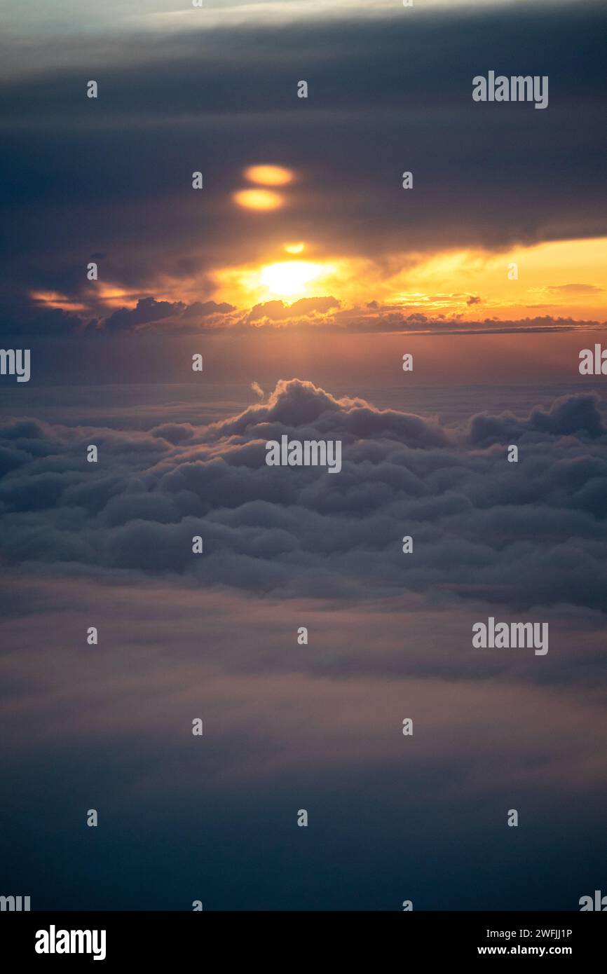 The View from a plane's window of the sun setting in cloudy skies Stock ...