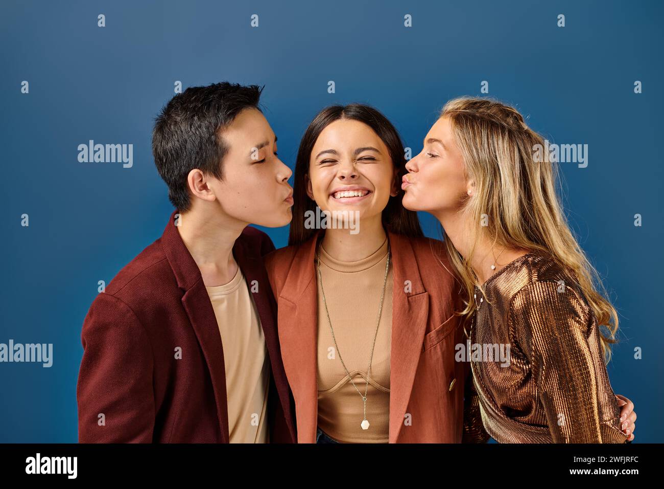 adorable interracial teenage boy and girl kissing their jolly friend in ...
