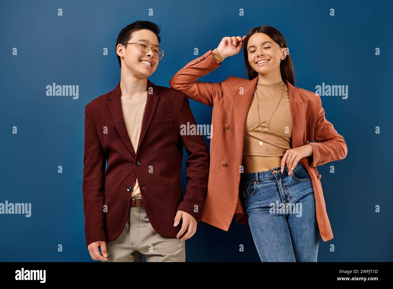 joyous elegant multicultural teens in stylish outfits smiling on blue ...