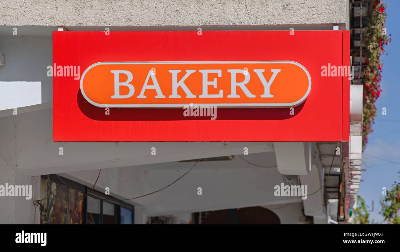 Red Sign Bakery Hanging From Wall in Front of Shop Stock Photo - Alamy