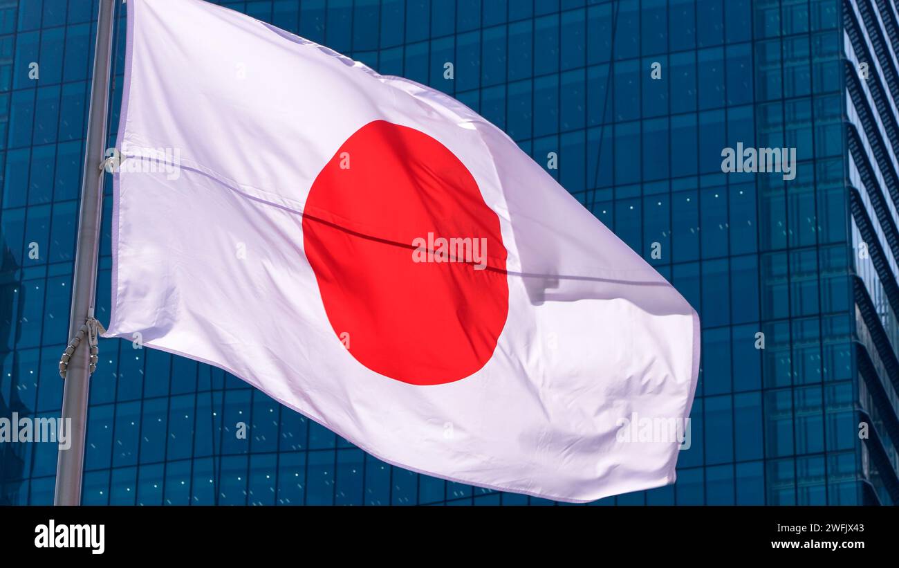 Japanese flag waving in a modern skyscraper city. Beautiful tall tower ...