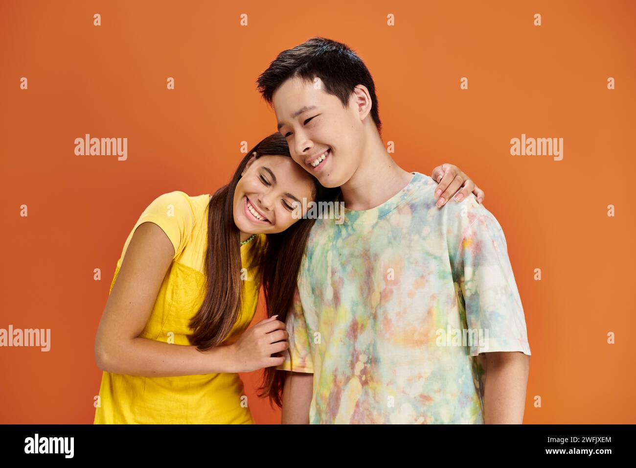 joyous diverse adolescents in vivid attires hugging and smiling ...