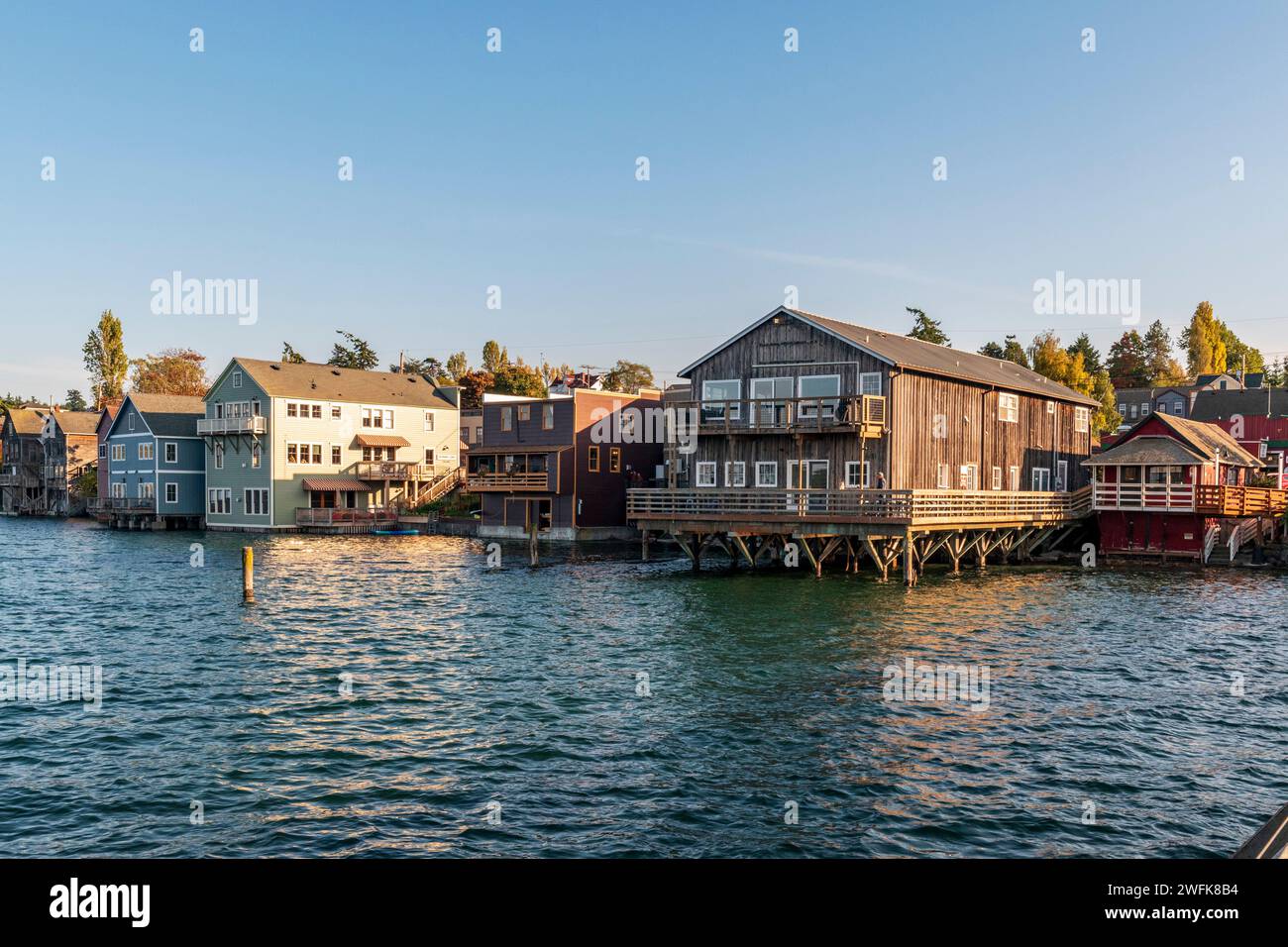 Historic wooden buildings built on pilings jut out into the water at ...
