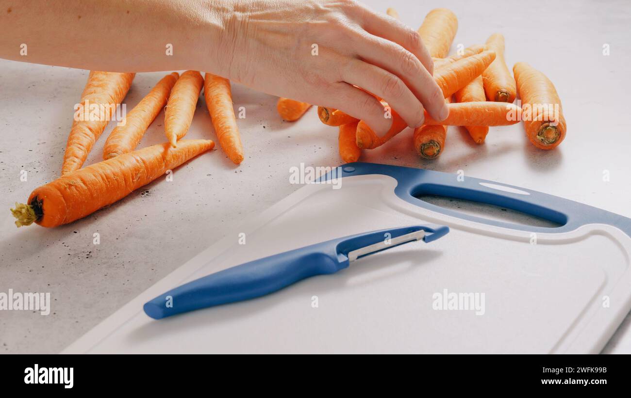 Woman's hands peeling carrots using a peeler knife, close-up view Stock ...