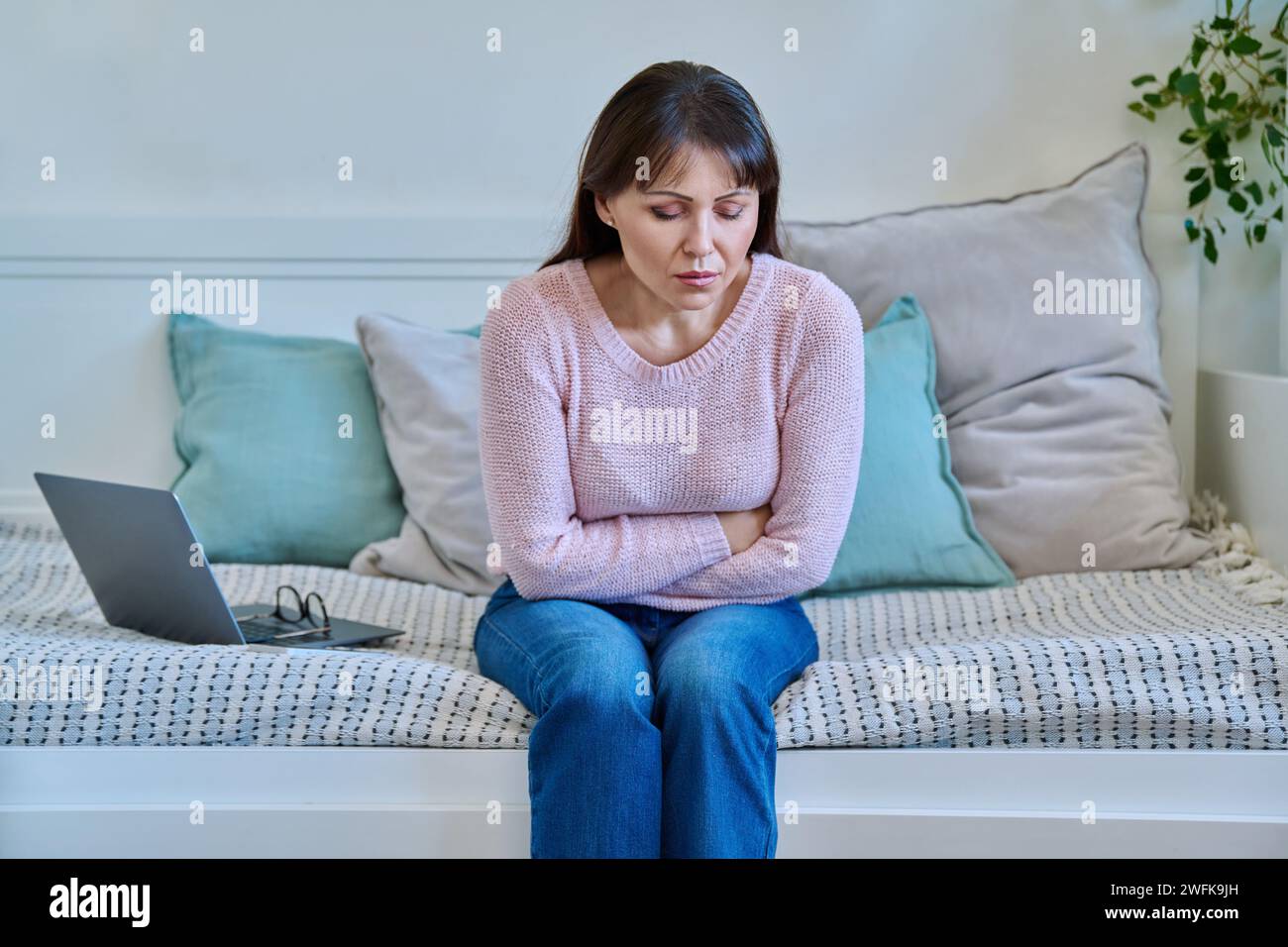 Woman experiencing painful stomachache hi-res stock photography and ...