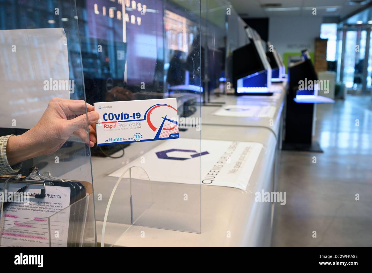 New York, USA. 30th Jan, 2024. A public library employee holds a COVID ...