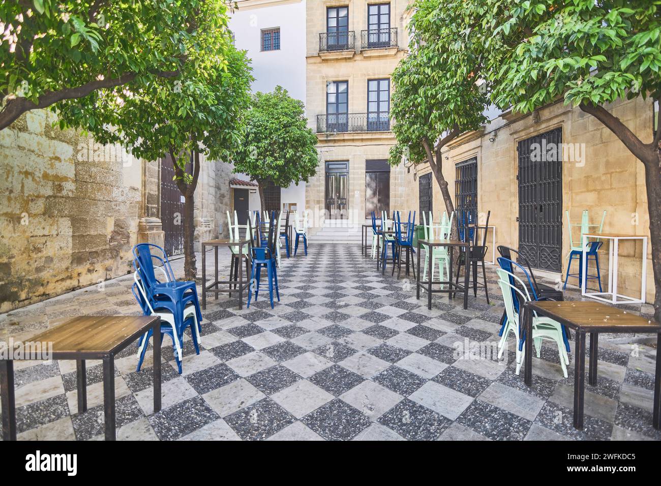 An inviting outdoor cafe with blue chairs on a cobblestone street ...