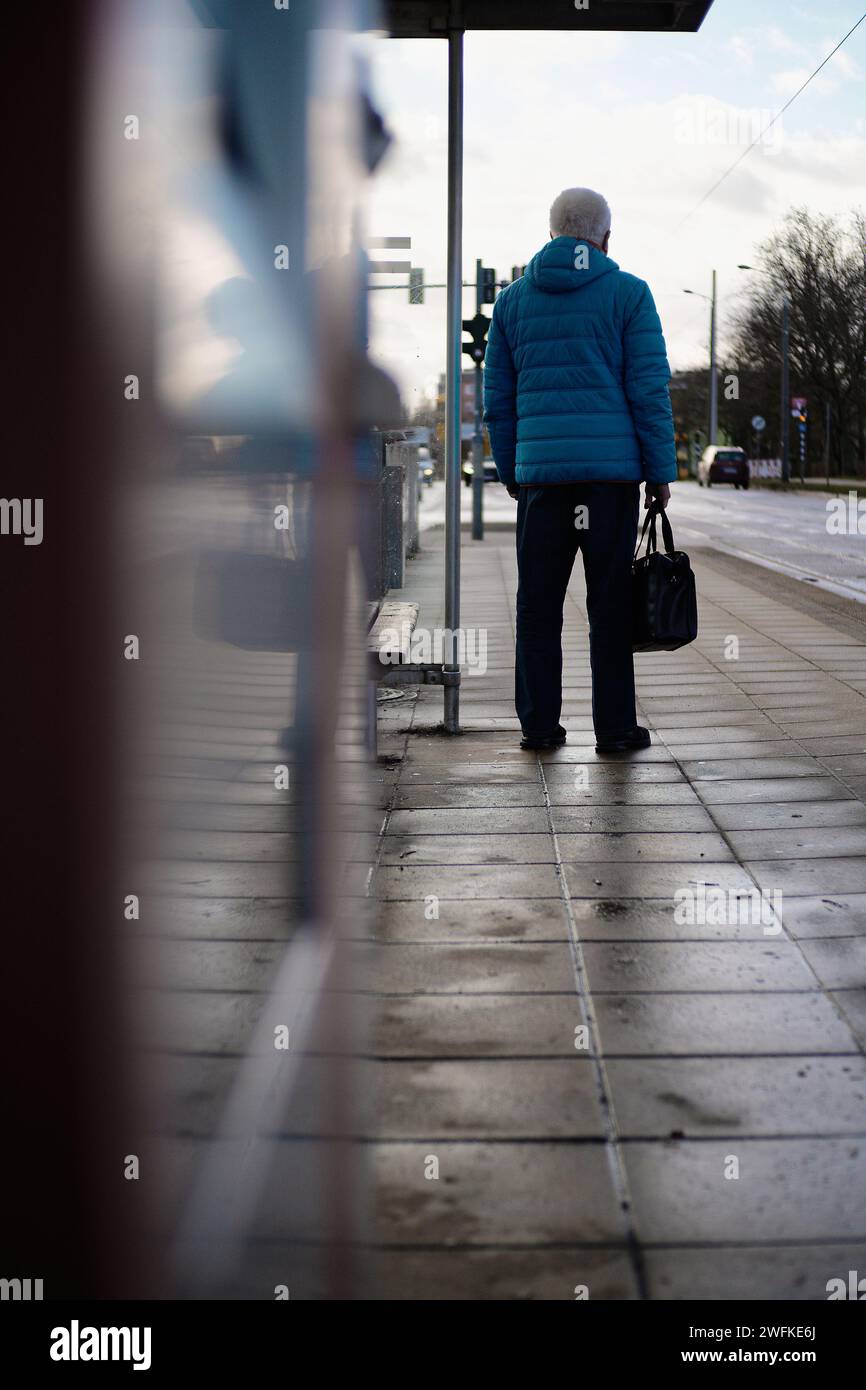 Senior man walking with hand in bag on road Stock Photo - Alamy