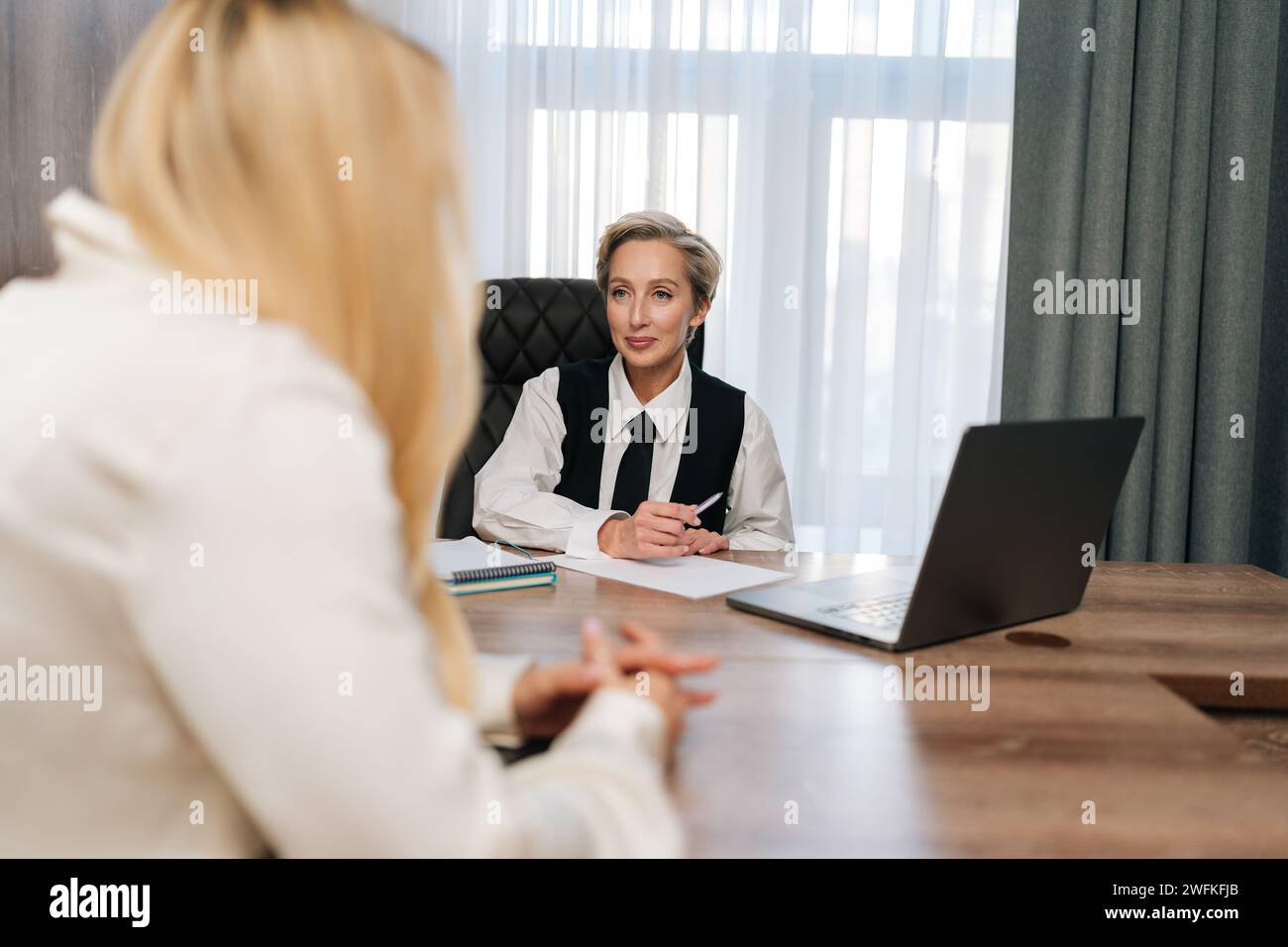 View from shoulder of unrecognizable female job seeker sitting at desk ...