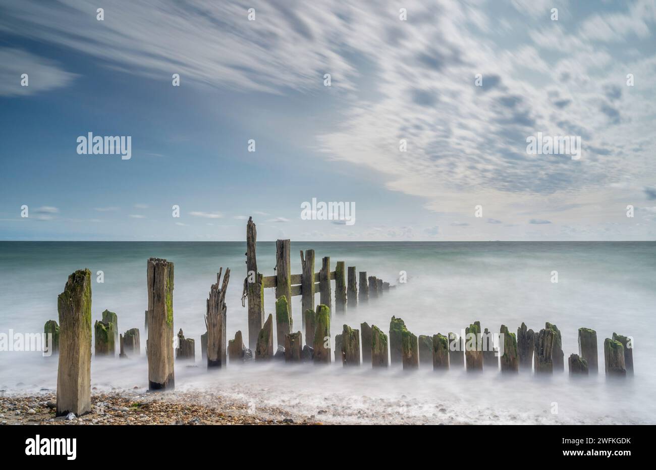 Old weathered groynes at Medmerry beach on the south coast with moody ...