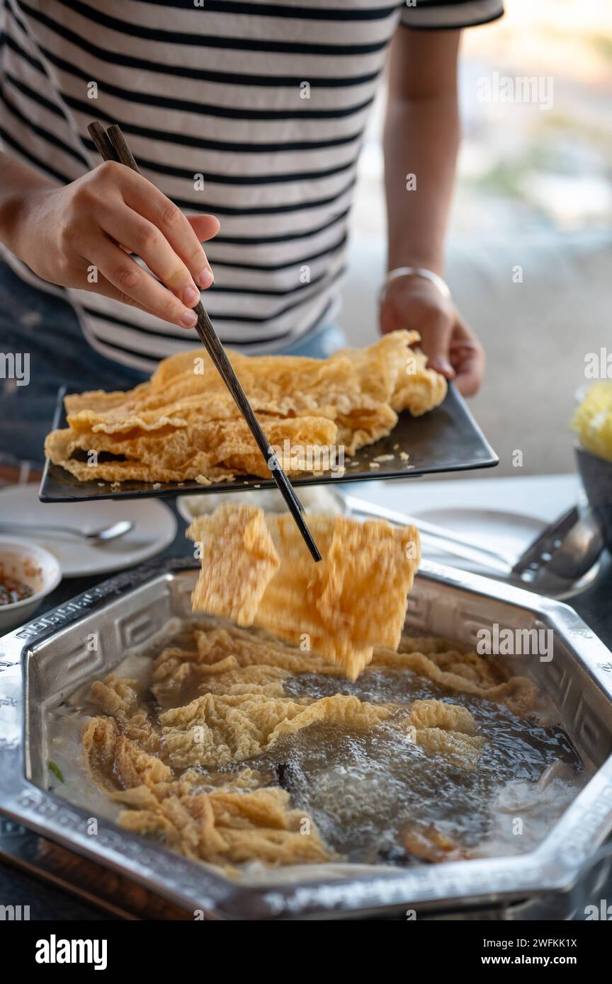 Female person has a hot meal with lots of ingredients to cook in a hot ...