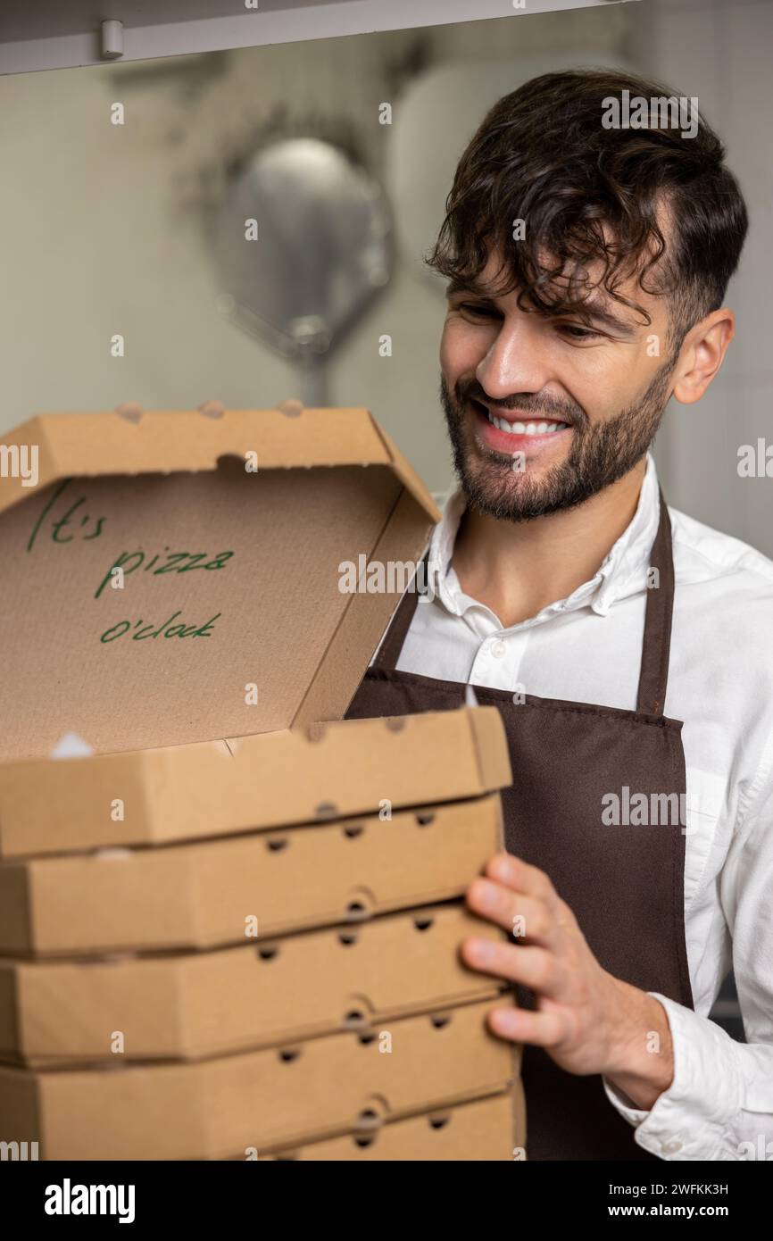 Male service man with many pizza boxes in pizzeria Stock Photo - Alamy