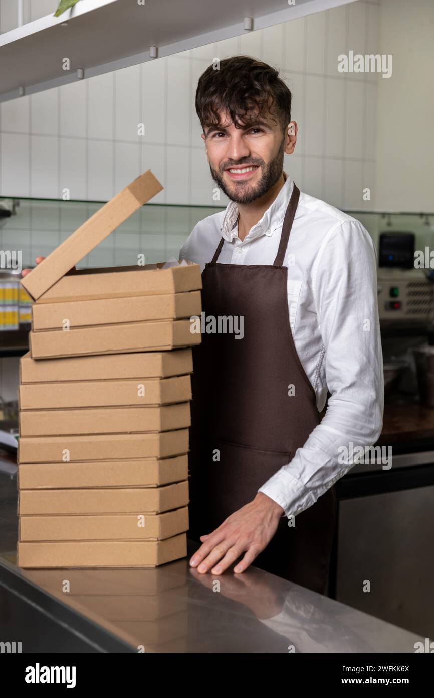 Male service man with many pizza boxes in pizzeria Stock Photo - Alamy