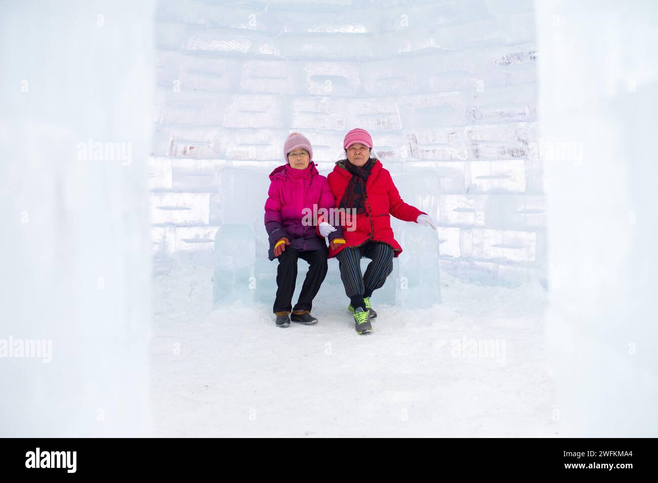 Two older women pose for a photo at inside an igloo at a winter ...