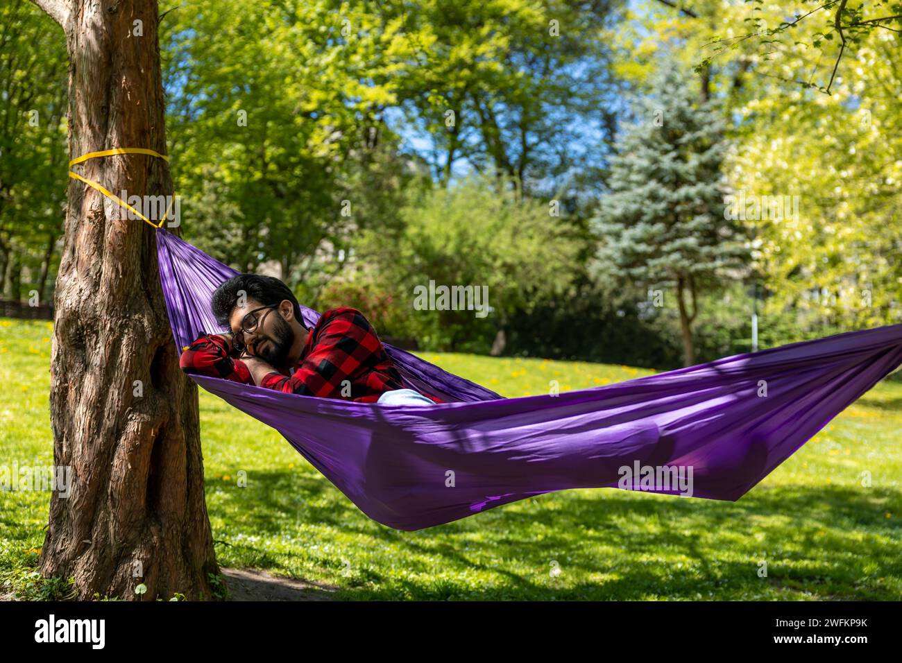 Brunette young man sleeping in hammock in the park Stock Photo - Alamy