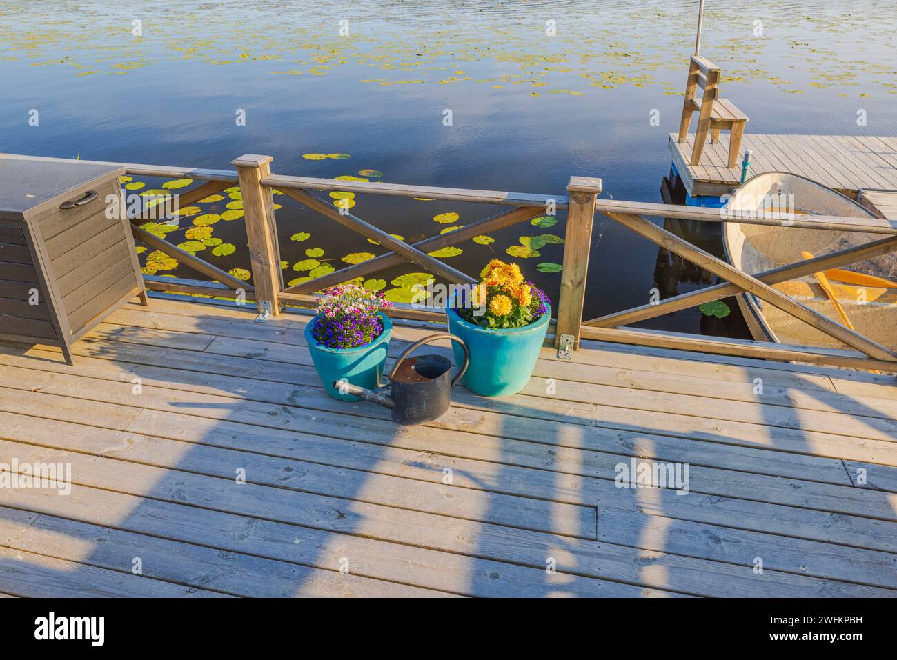 Lake shore view with boat dock and flower pots, adorned with flowers ...