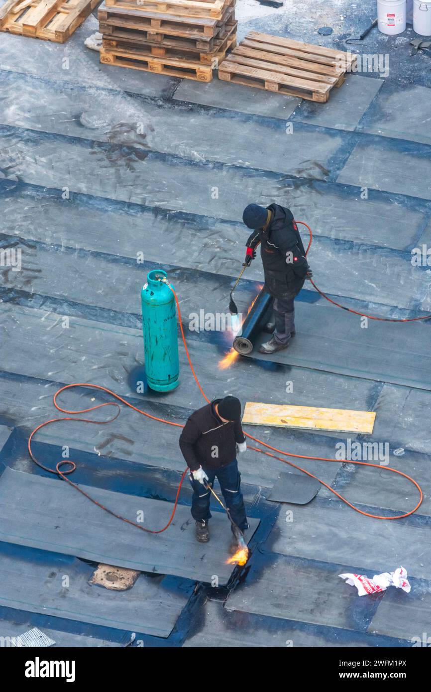 Vienna: Construction workers doing waterproofing work on a building ...