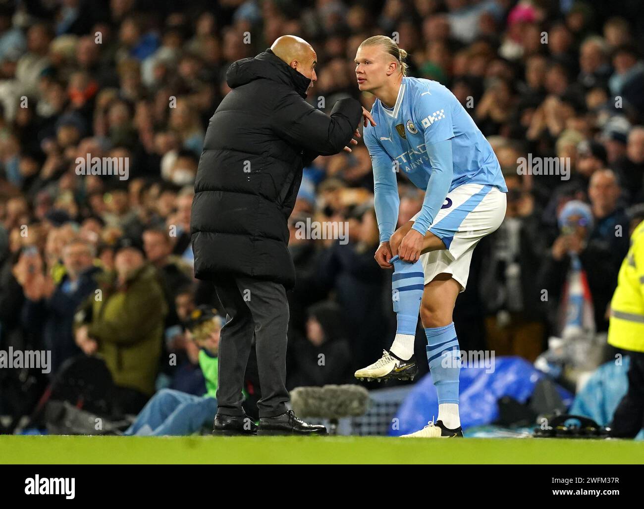 Manchester City manager Pep Guardiola speaks with Erling Haaland (right) before being ...