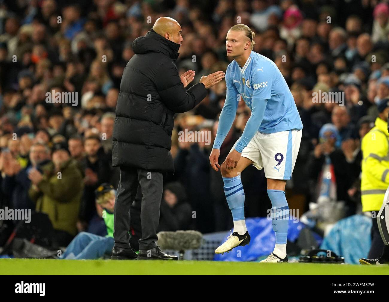 Manchester City manager Pep Guardiola speaks with Erling Haaland (right) before being ...