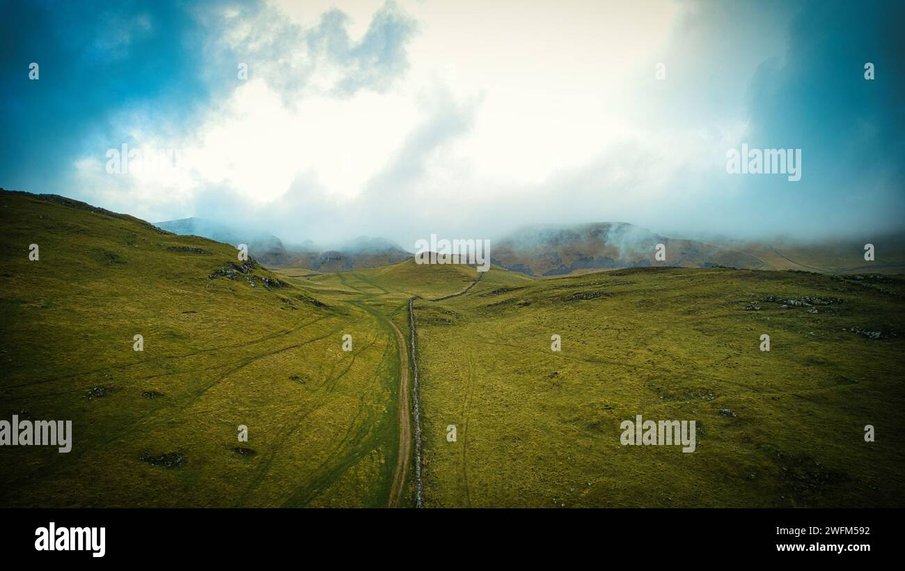 Misty hills with a narrow path under a dramatic sky Stock Photo - Alamy