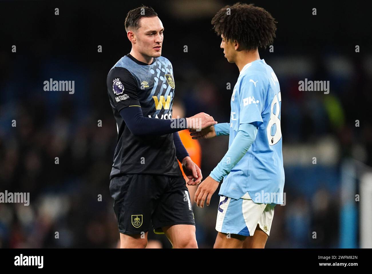 Burnley's Connor Roberts (left) and Manchester City's Rico Lewis shake ...
