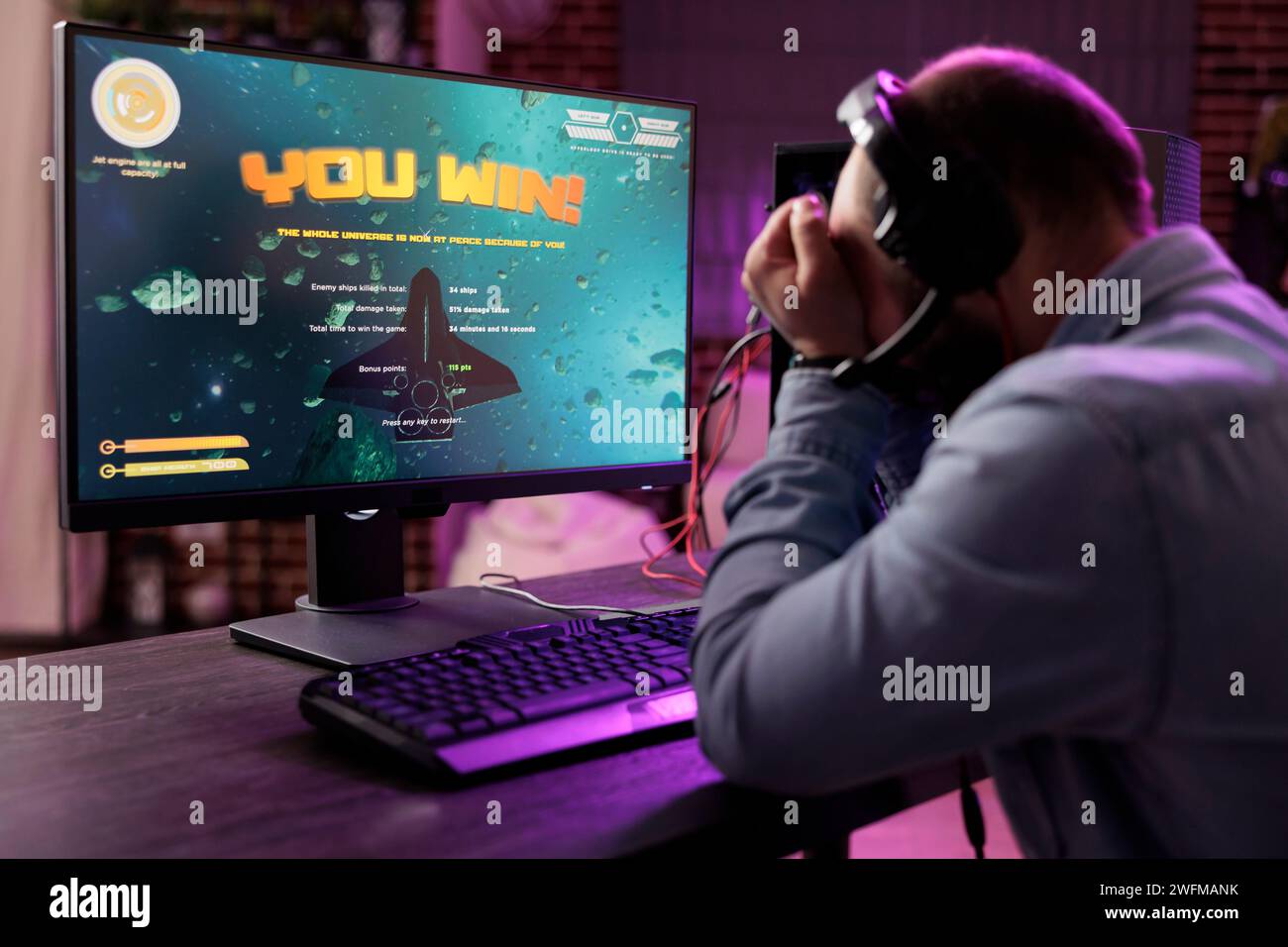 Gamer playing intense classic arcade spaceship racing videogame, wiping ...