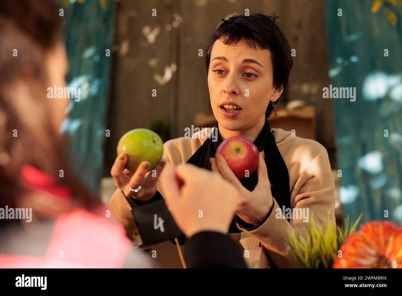 Farmers market seller smelling red apples at marketplace, selling fresh ...