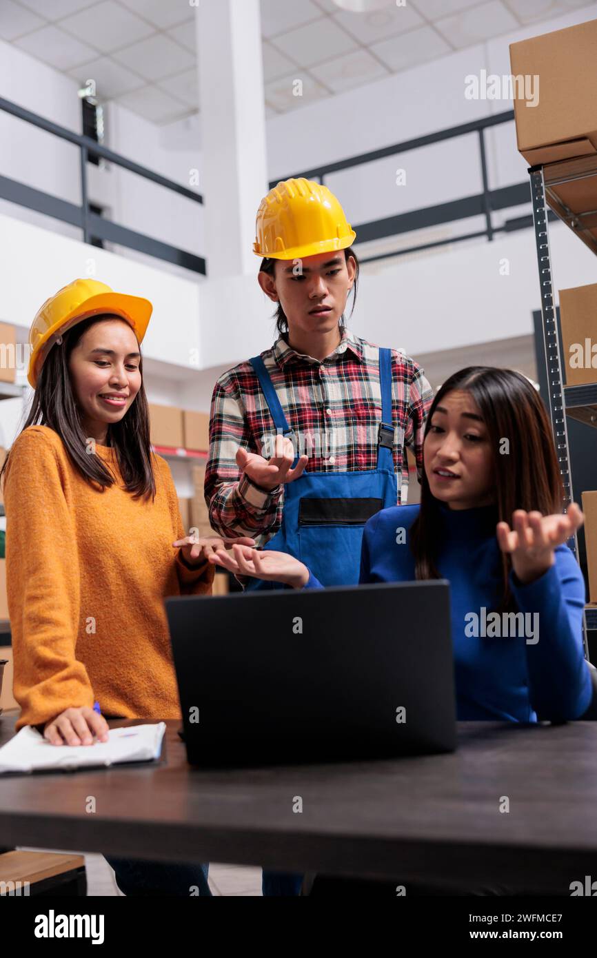 Asian storehouse workers team analyzing shipment checklist together and ...