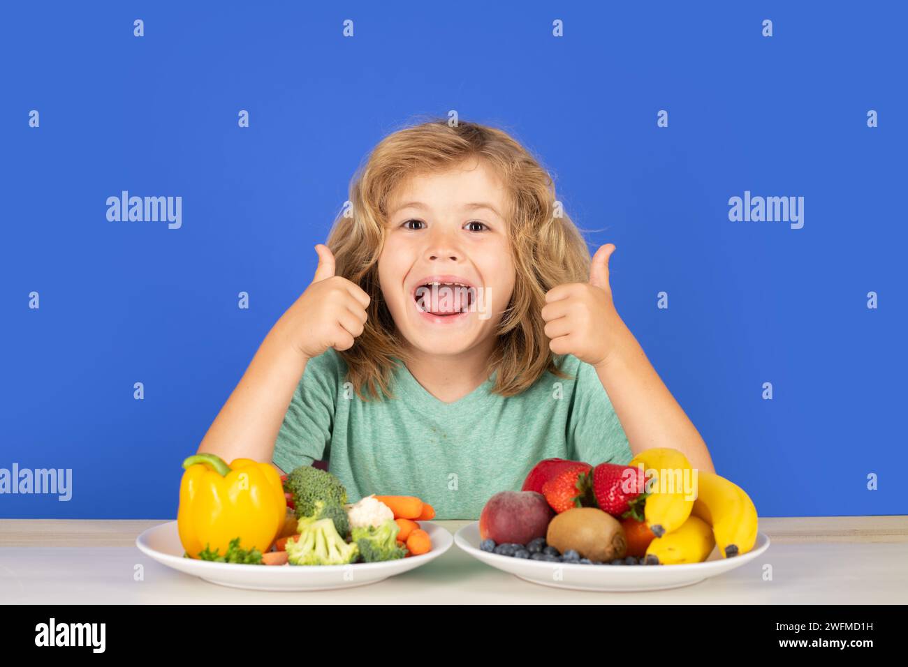 Excited child eating fresh fruit. Kid with fruits and vegetables ...